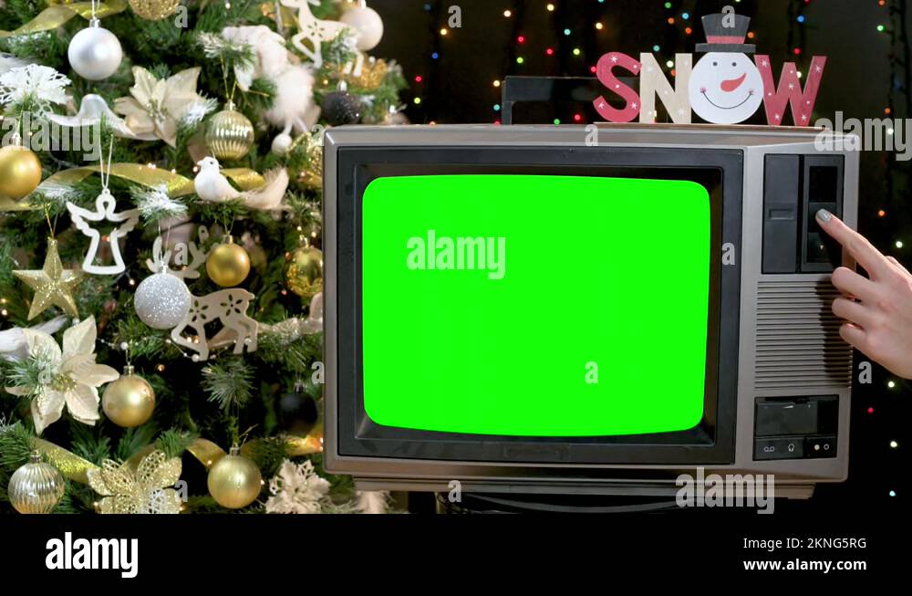 Woman hand turn on Vintage tv with green screen in front of Christmas ...