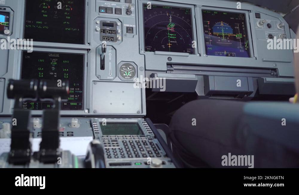 An electronic flight control panel with relaxing copilot leg in his ...