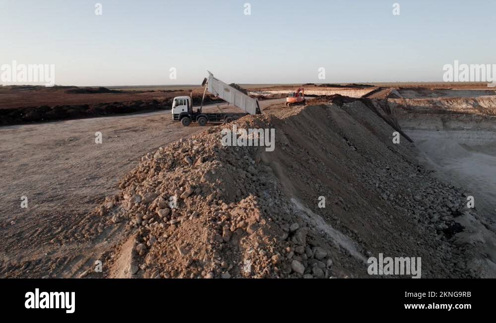Tipper in mining quarry. Truck pours stones from body while working in ...