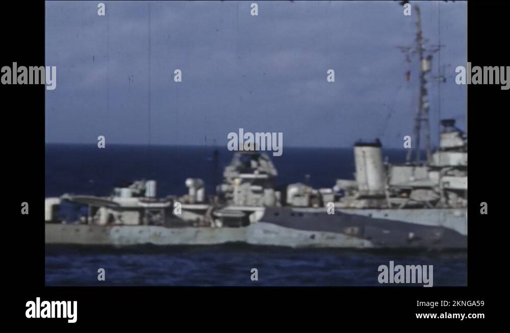 1940s: Large battleship. Many ships sailing together. Soldiers crouched ...