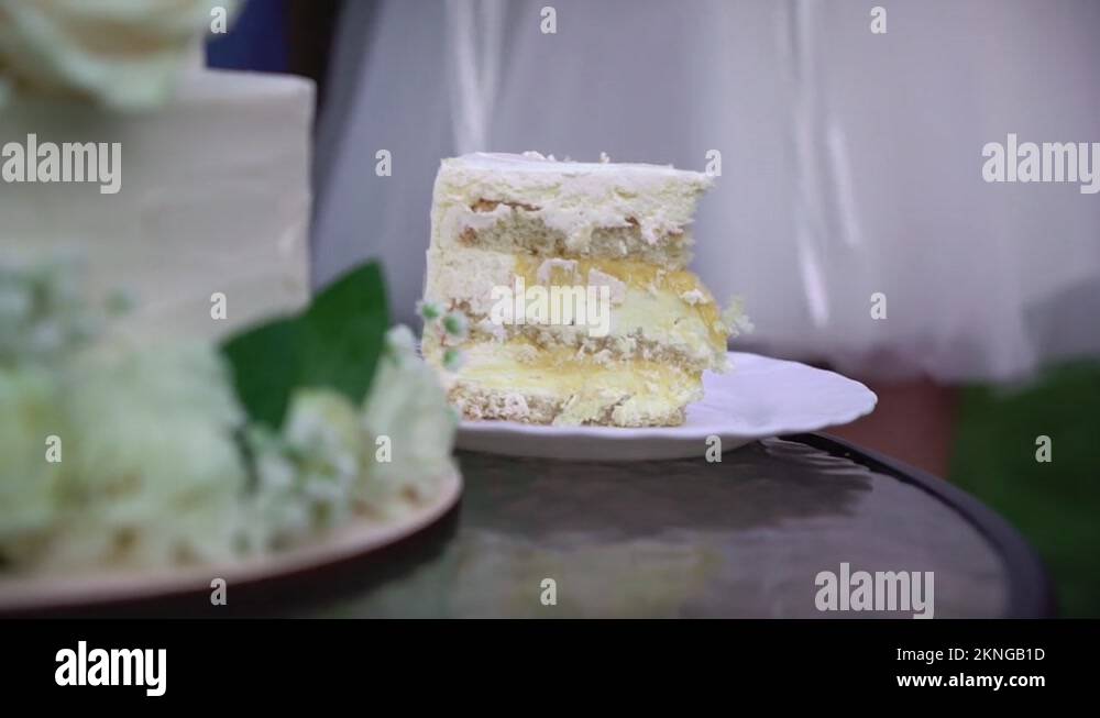 Cutting piece of wedding cake. Bride and groom with knife at reception ...