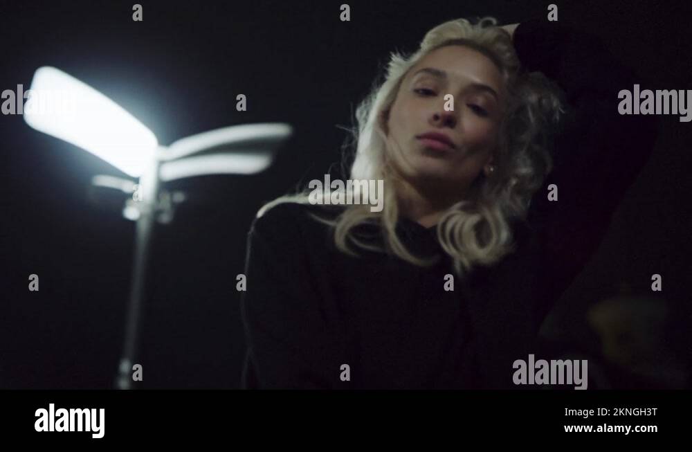 Young girl looking camera posing for photo at night sky in city lights ...