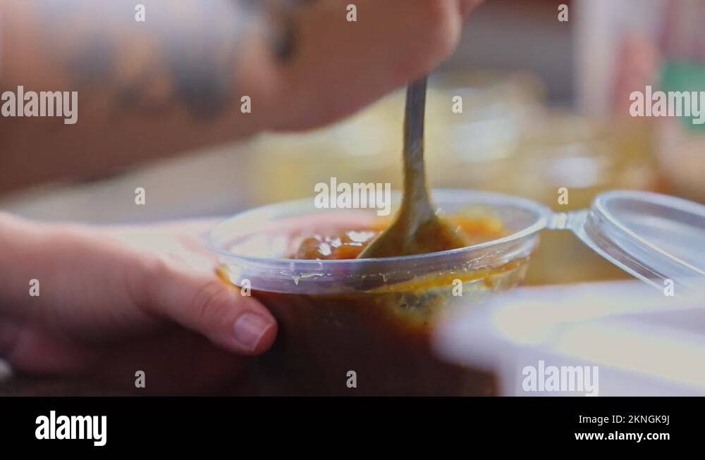 Container of thick fruit jam preserves made from plants harvested from ...