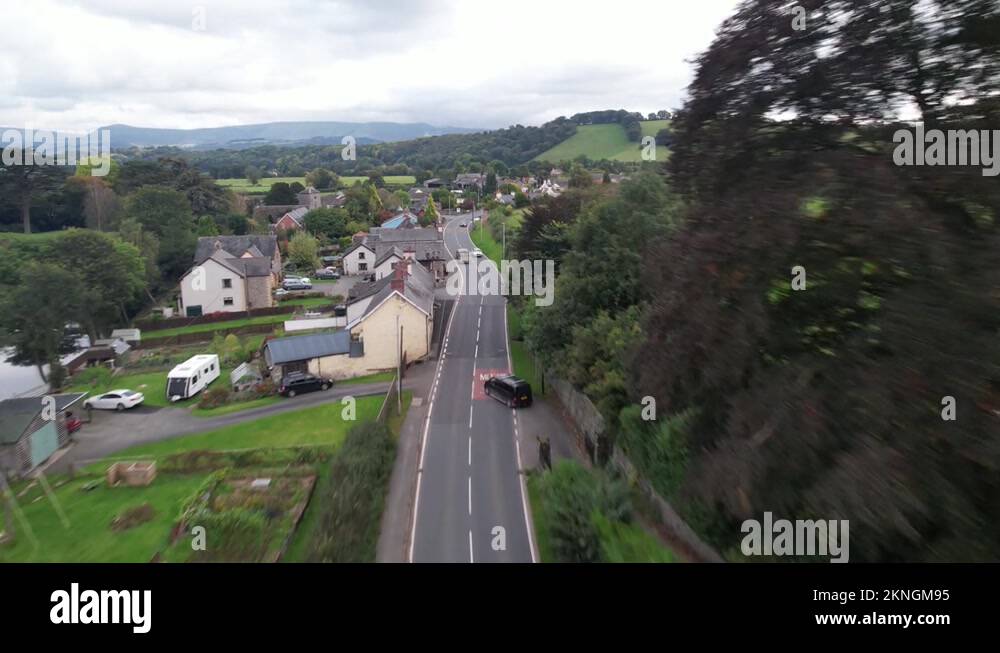 Road winding in village in countryside, low traffic between houses ...