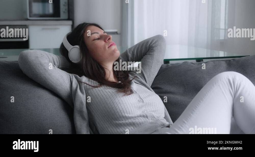 Calm young woman in headphone having healthy daytime nap dozing ...