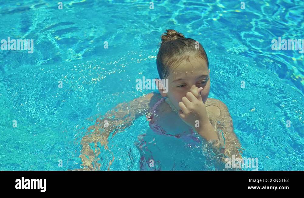Little beautiful girl swimming in the pool, playing in the water Stock ...