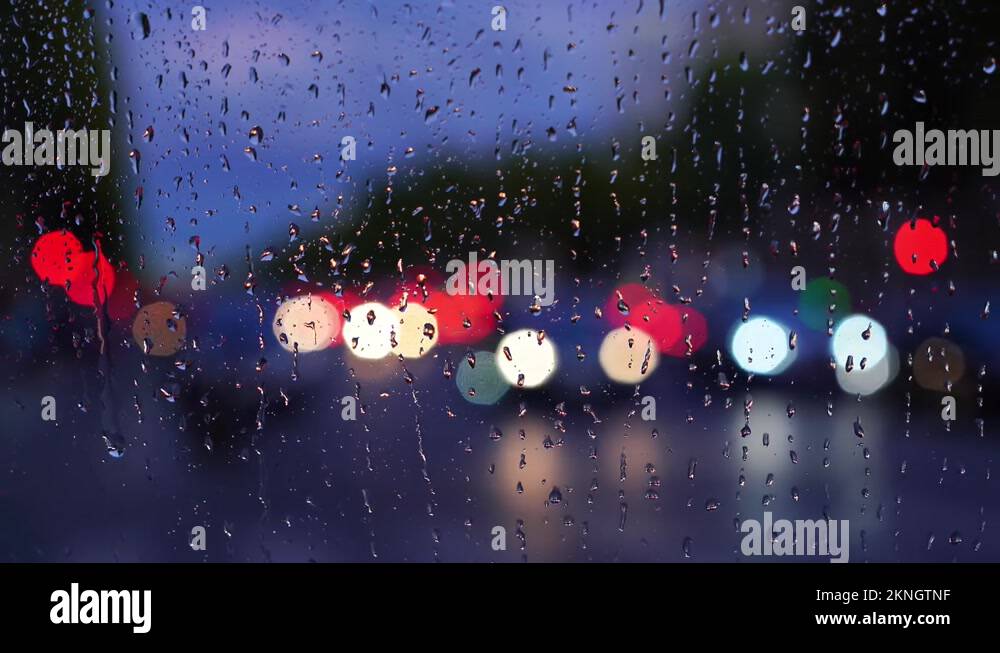Panning shot from left to right of rainwater dripping down the window ...