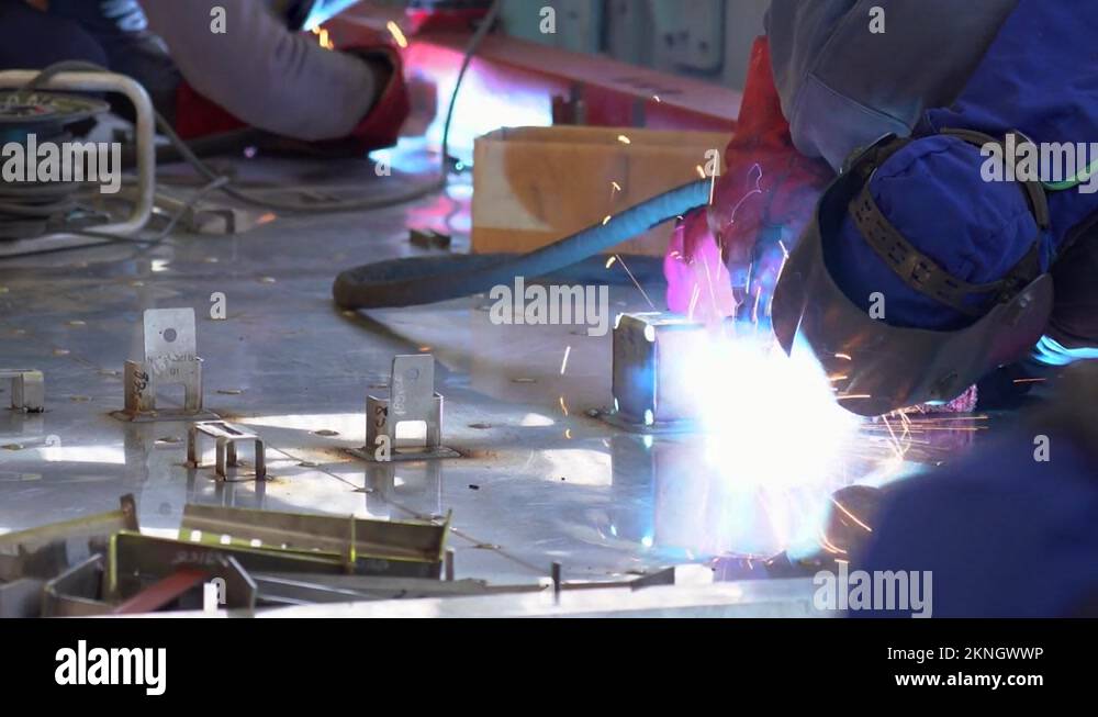 Two Welders Welding On Stainless Steel Railcar In A Train Factory ...