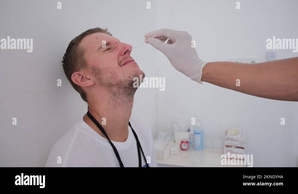 Reaction of young adult man doing covid-19 swab test procedure in ...