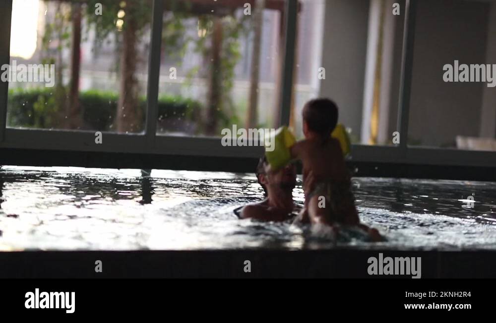 Toddler child playing with father at swimming pool. baby diving into ...