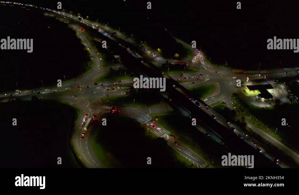 British motorway roundabout junction background at night with traffic ...
