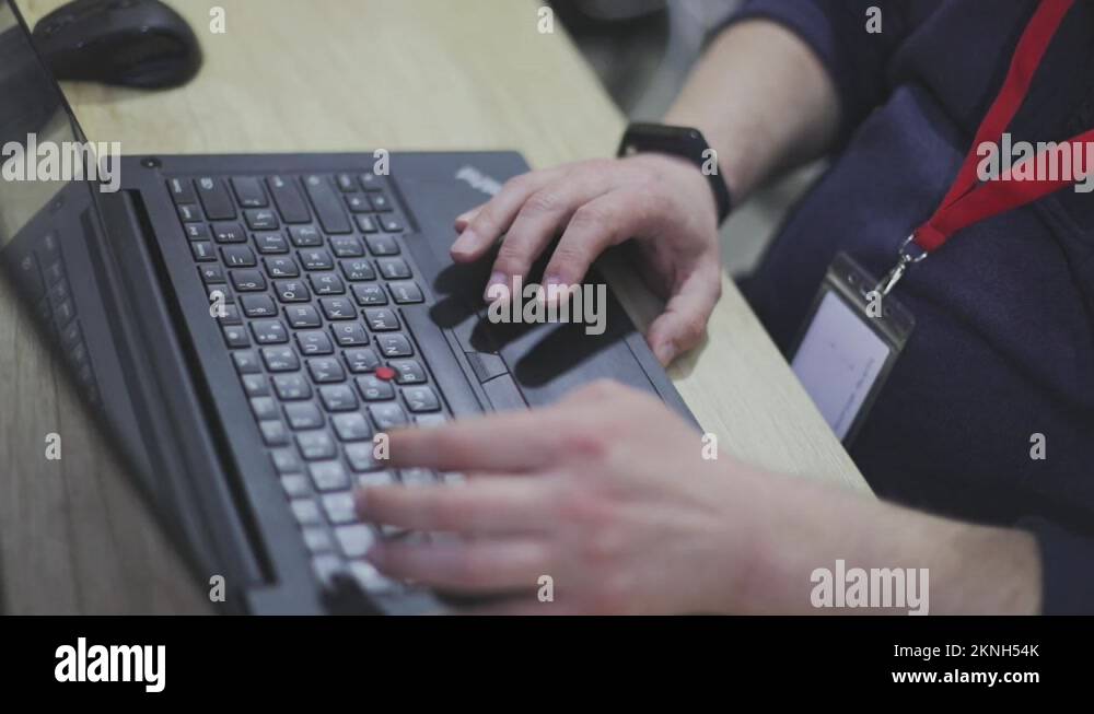 Male hands are typing text on laptop keyboard close-up. The man is ...
