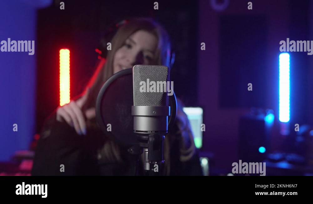 Side view woman singing in the microphone and wearing headphones Stock ...