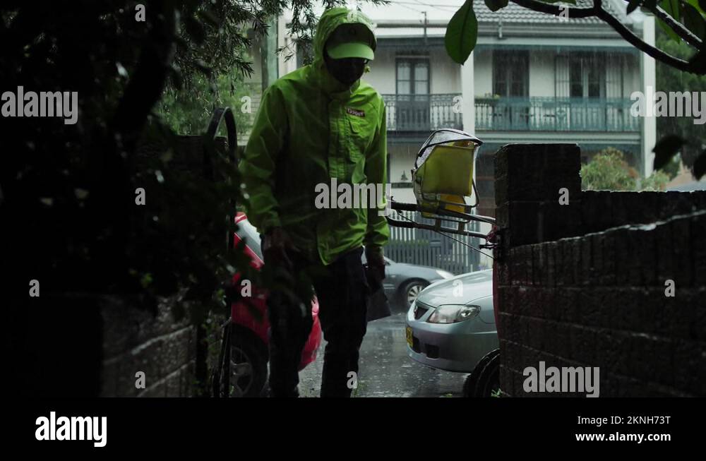 Friendly postman in pouring rain delivers post in Sydney slow motion 4K ...