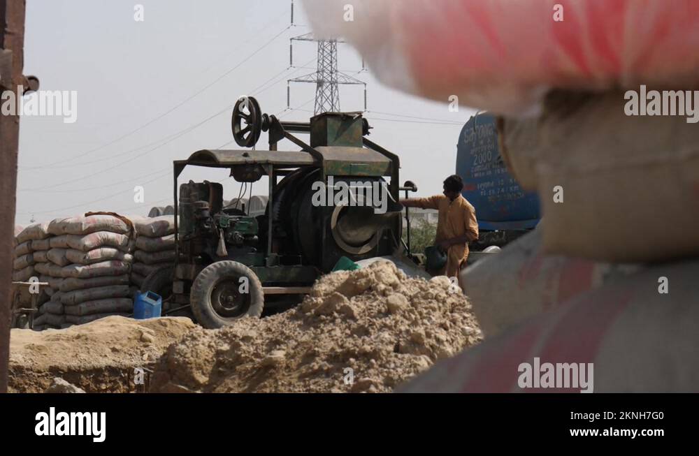 Workman Standing Near Cement Mixer At Construction Site In Karachi ...
