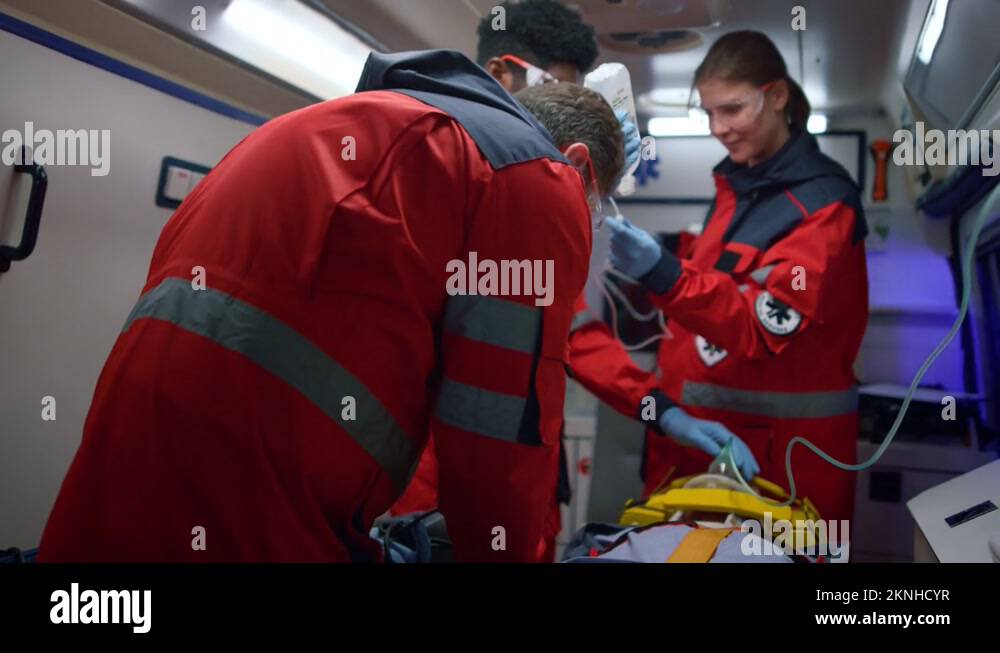 Paramedics rescuing patient in ambulance. Medical team providing first ...