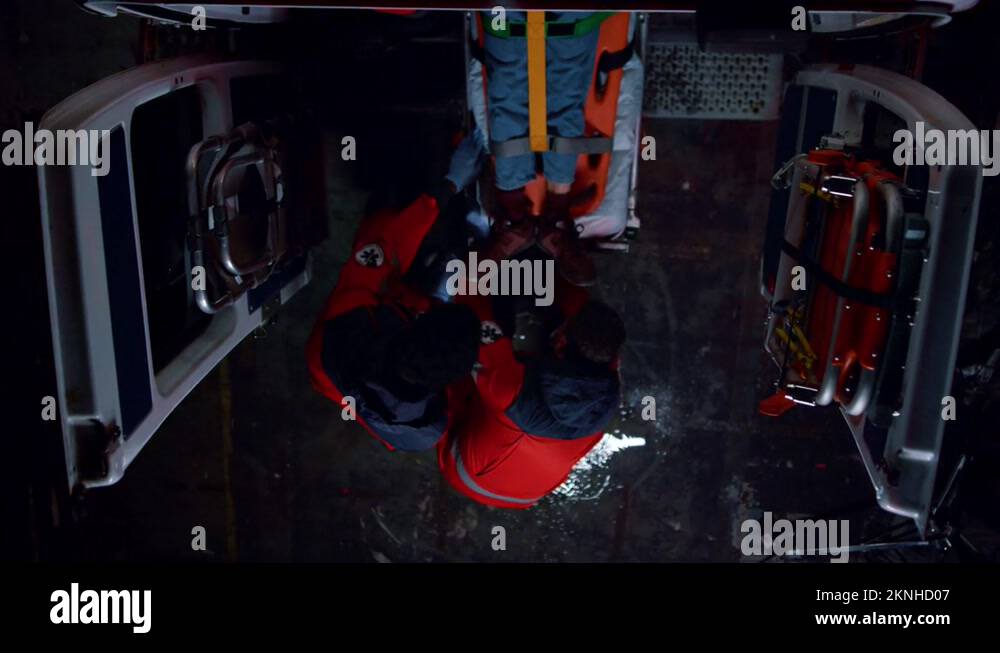Multi ethnic paramedics moving injured man on stretchers in emergency ...