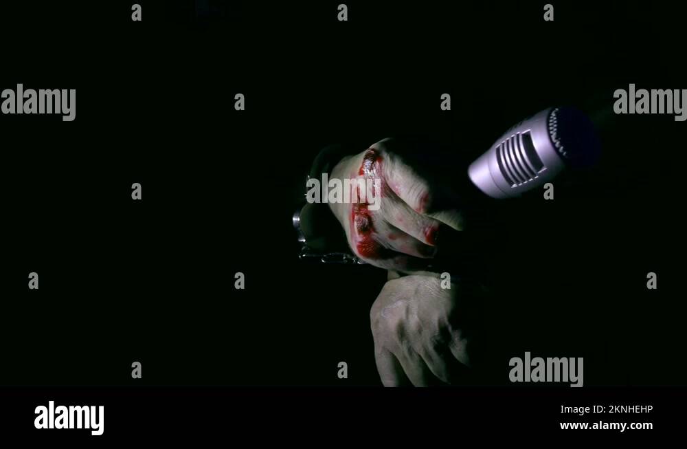 Microphone in a bloody hand handcuffed Stock Video Footage - Alamy