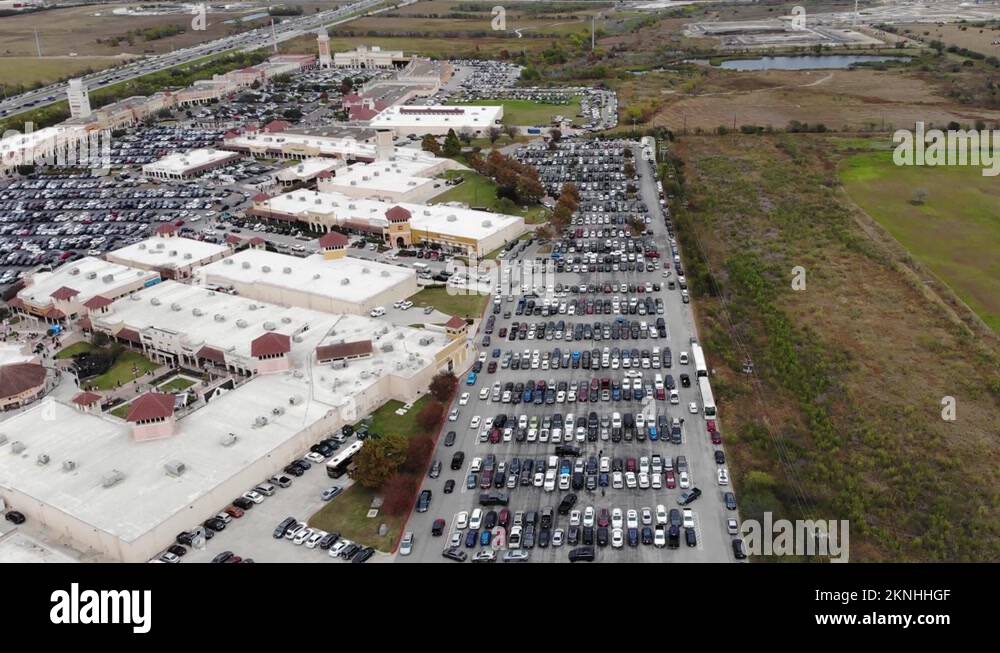 Aerial flyover full parking lot at outlet mall with shopping stores ...