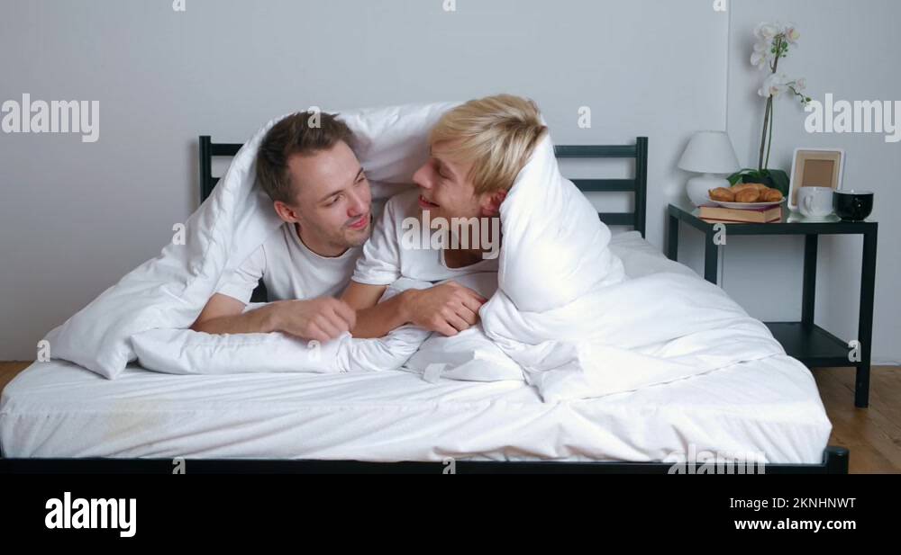 Young gay couple lying on bed together in bedroom, hugging and kissing. LGBT Stock Video Footage ...