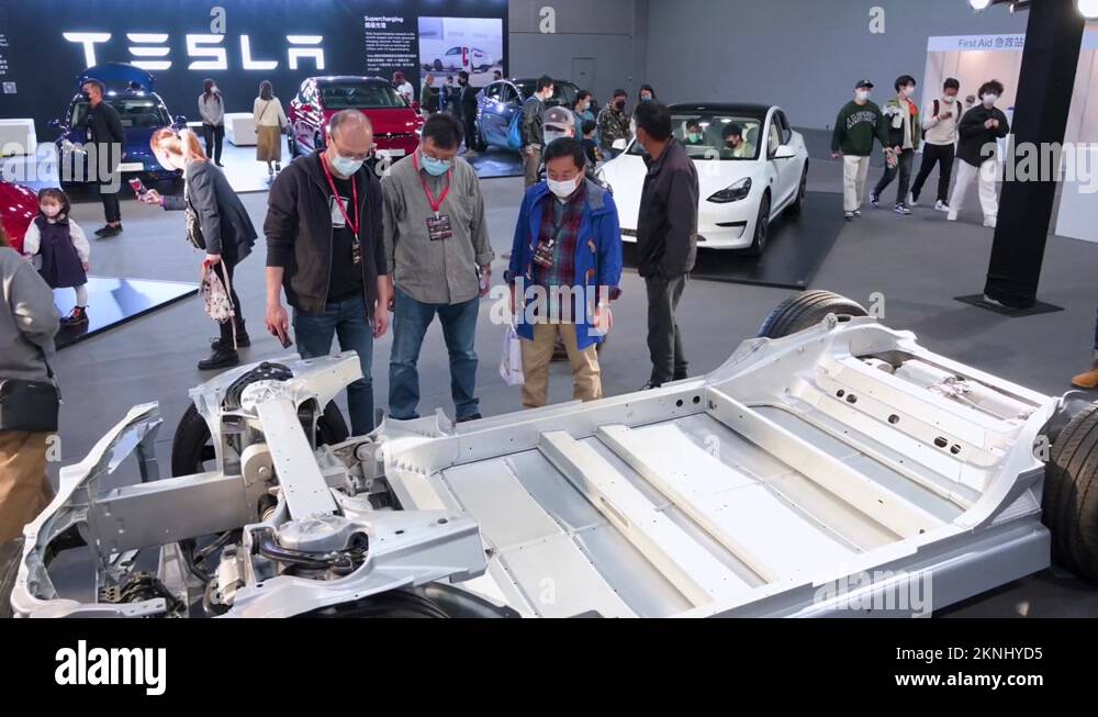 Visitors look and test at a Tesla Motor chassis car and vehicle frame ...