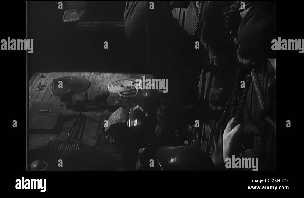 1940s: Ship. Soldiers climb down rope ladder into transport boat. Boats ...