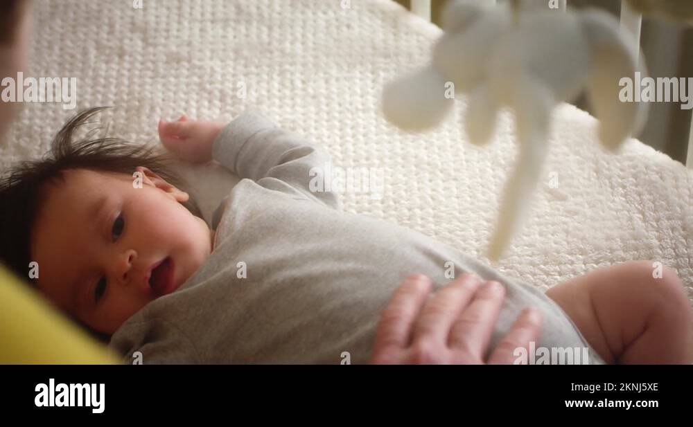 Happy young father strokes newborn baby lying in a child crib Stock ...