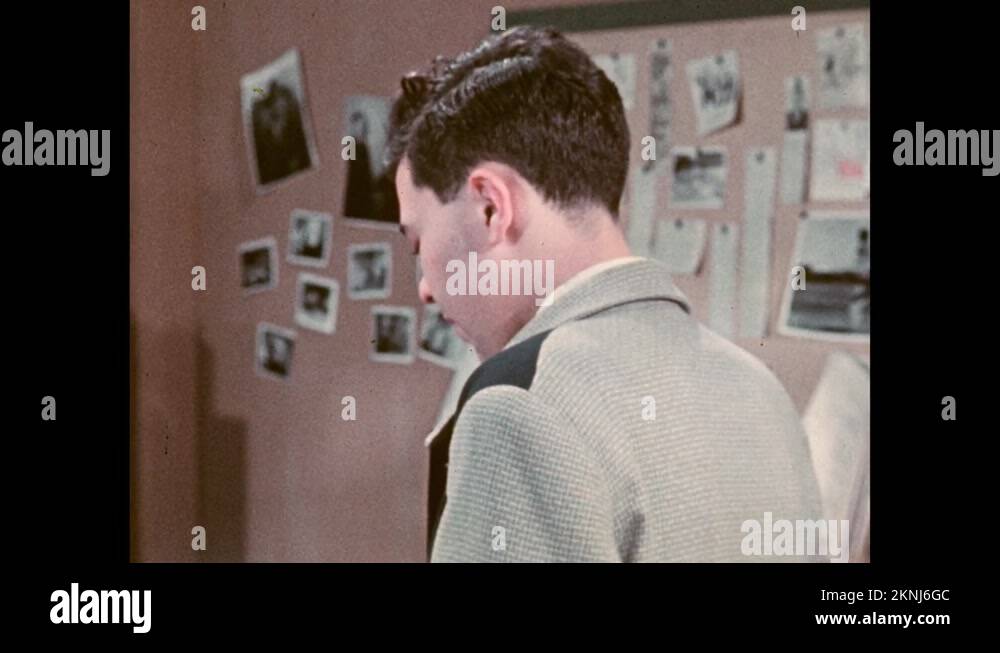 1950s: Film slate. Boy looking down at paper, turns and starts talking ...