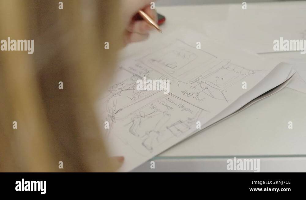 Fashion designer drawing a new line of clothing - over the shoulder ...