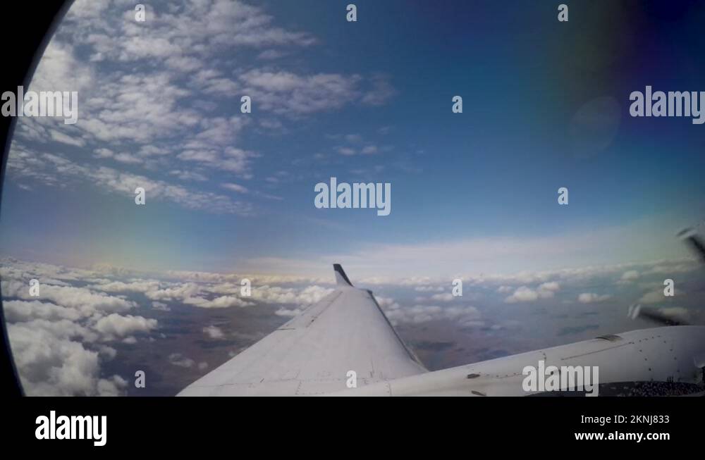 Small propeller airplane flying through clouds wing engine POV time ...