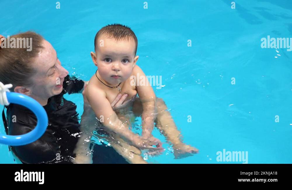 Child looks up in surprise at the camera during a workout in swimming ...