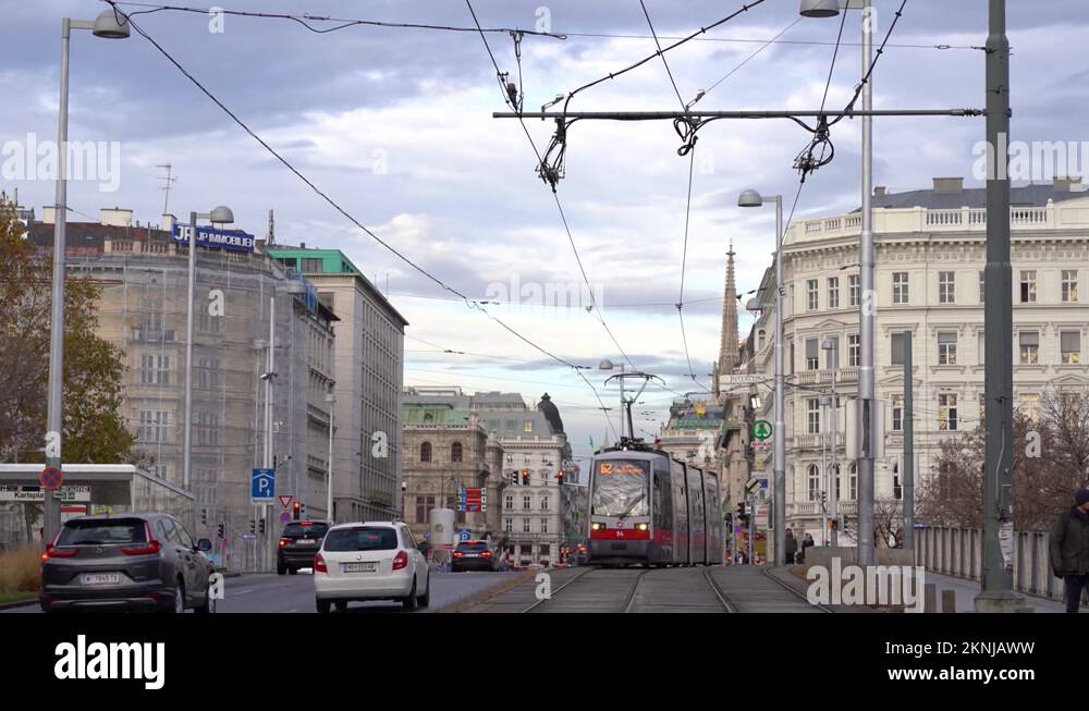 Tram driving through street in Vienna with view of 1st district in ...