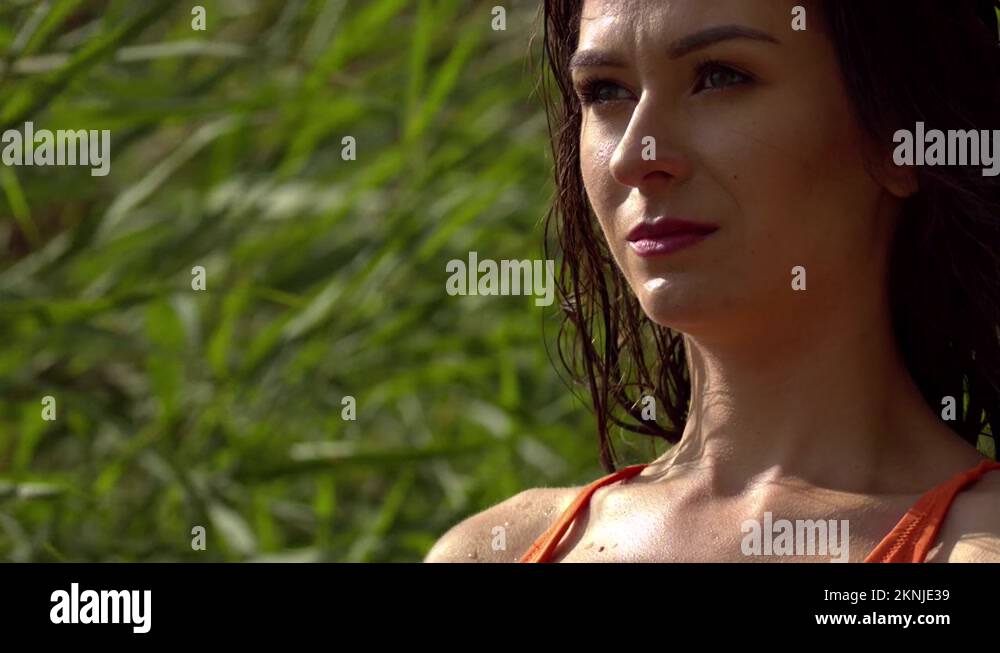 Closeup of the face of a young woman who is lit by the sun, she is ...