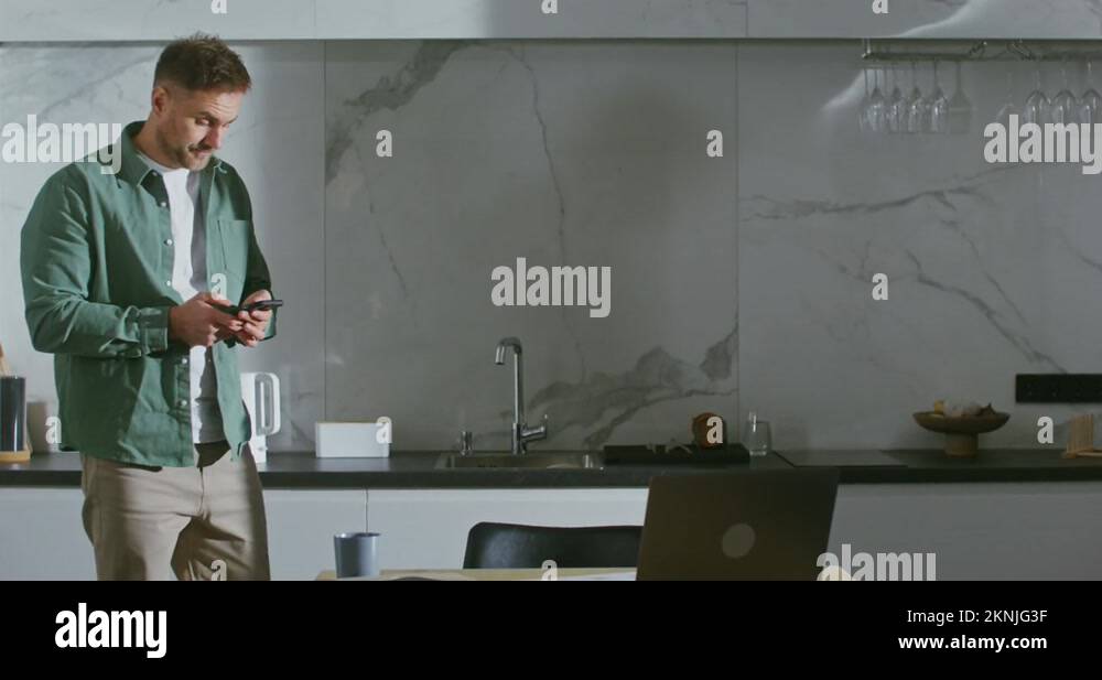 A man texting on a mobile phone interrupted from work on a laptop Stock ...