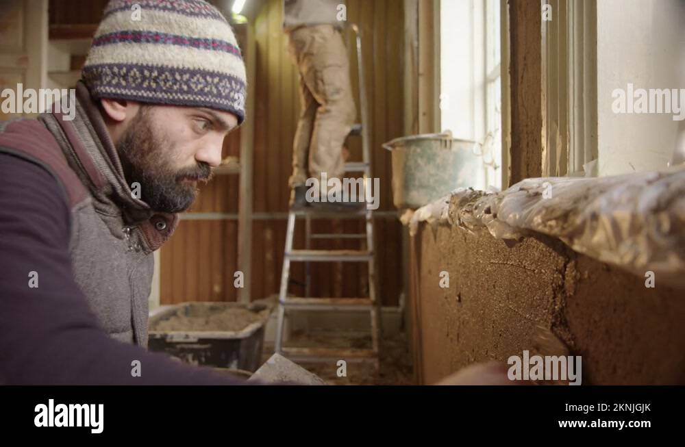 An Asian man plastering his house walls with a clay render Stock Video ...