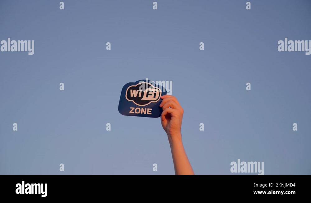 Wi-Fi Zone sign sticker in man's hand on sky background Stock Video ...