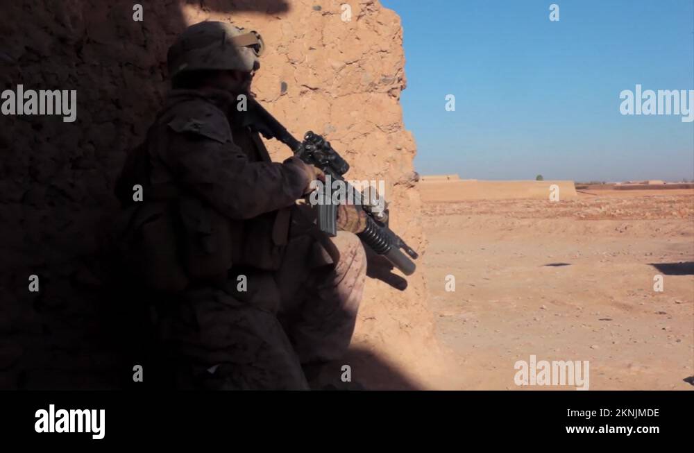 2010s: Soldier crouches behind rock holding weapon. Soldier walk in ...