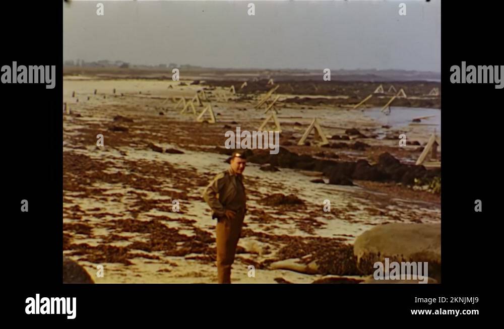 1940s: wooden barricades set up on beach, family posing together for ...