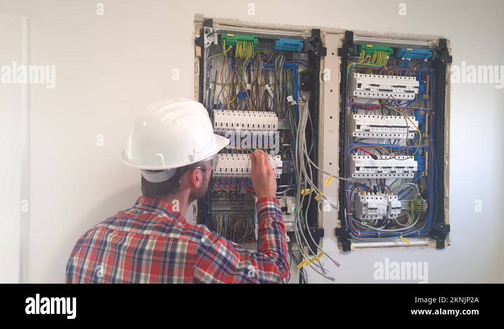 Skilled professional technician fixes switchboard in electrical panel ...