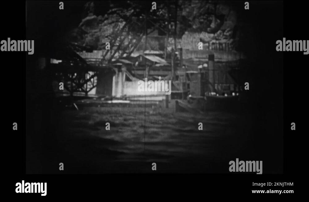 1940s: Ship. Men work in submarine control room. Man looks into ...