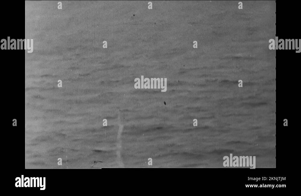 1940s: Ships at sea. Submarine fires missile. Explosion. Submarine ...