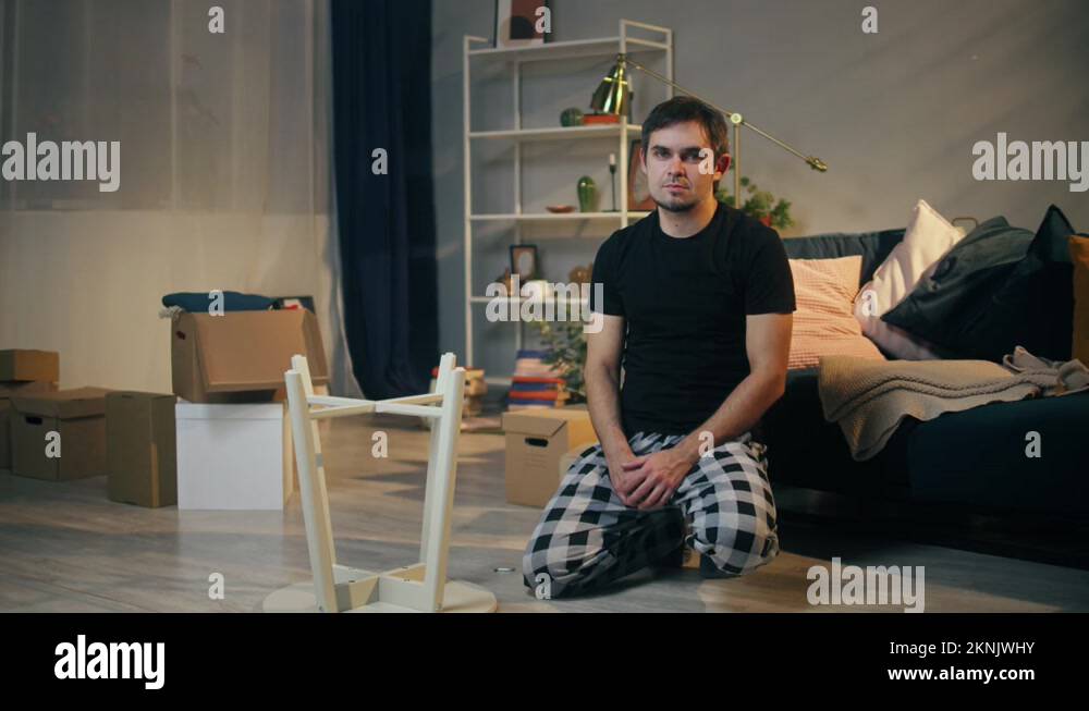 Handyman portrait in living room. Man assembling wooden furniture ...