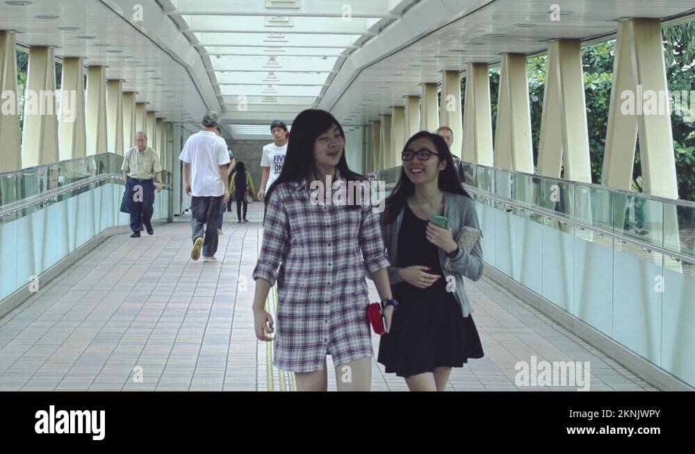 Two young Chinese female friends from Hong Kong walking smiling in ...