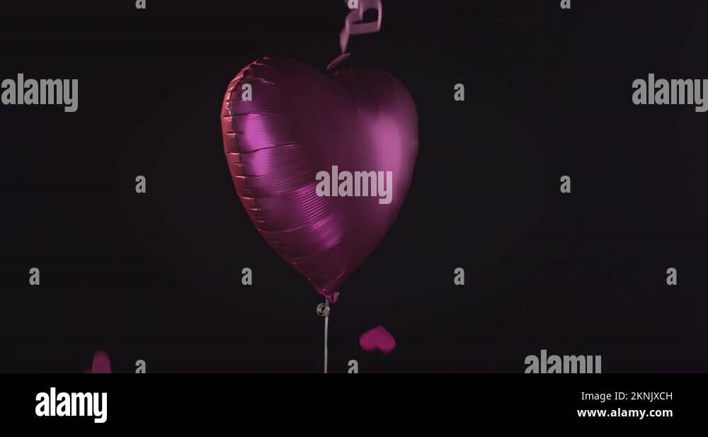 Pretty pink helium balloon in a heart shape with pink hearts falling all Stock Video Footage - Alamy
