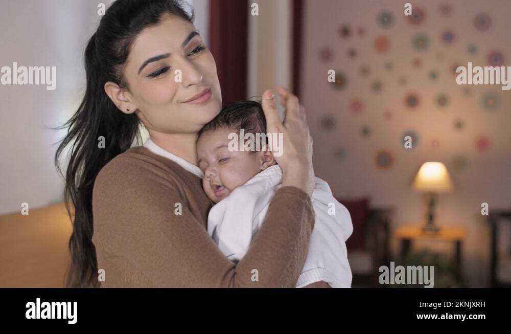 A young Indian mom holding and soothing her daughter - mother-daughter ...