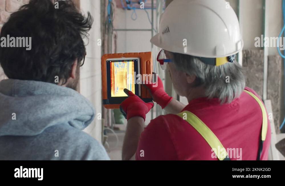 Back view of contractor and builder use infrared camera at construction ...