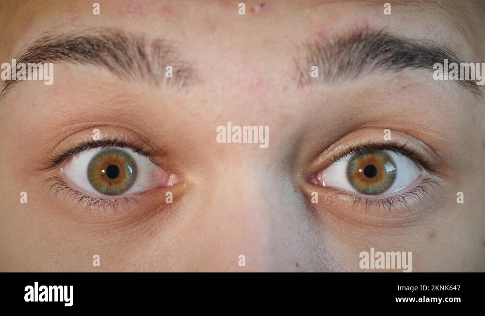 Close up of shocked and surprised male face with hazel eyes raising ...