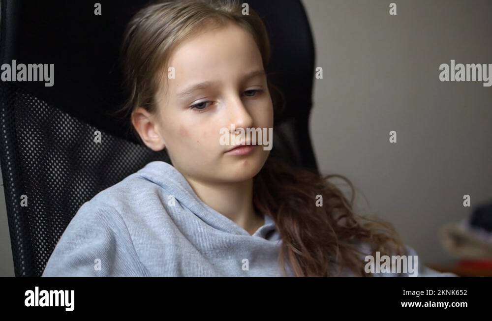 Little sad girl is sitting on black office chair, punishment, serious ...