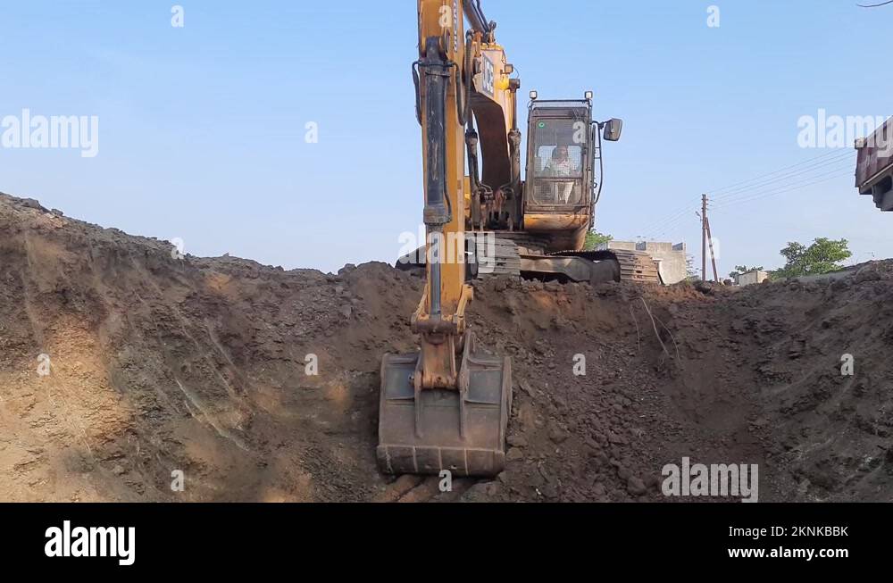 An excavator loads sand Moorum into a tractor at the construction site ...