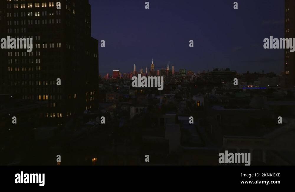 Fly between high rise office buildings in evening city. Revealing ...